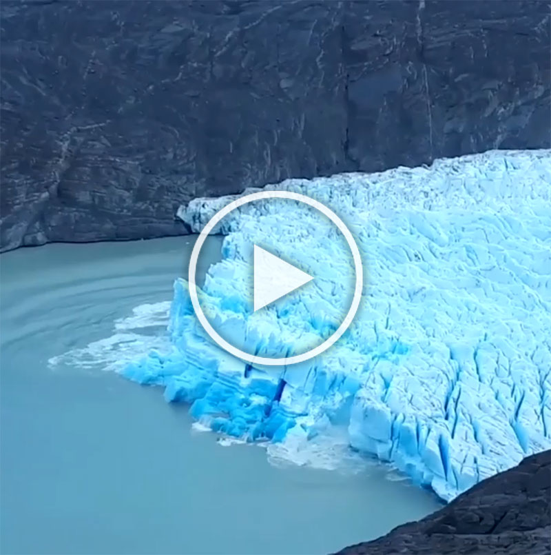 Iceberg flipping over revealing very old blue ice